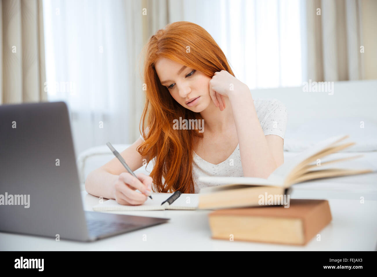 Young redhead woman doing homework at home Stock Photo - Alamy
