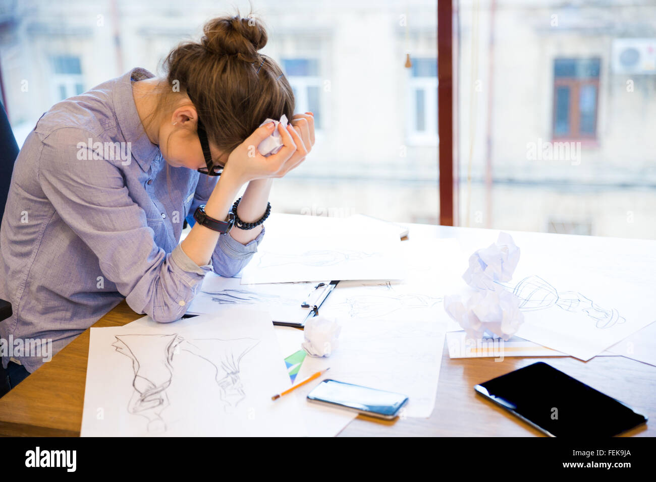 Sad despaired young woman fashion designer sitting in office with ...