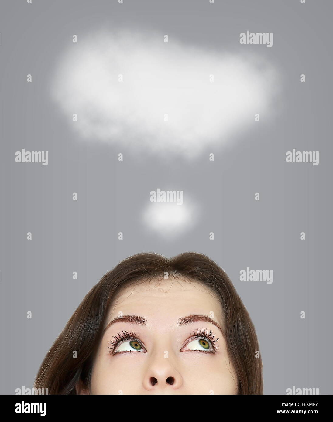 Thinking woman looking up on white cloud on grey background Stock Photo ...