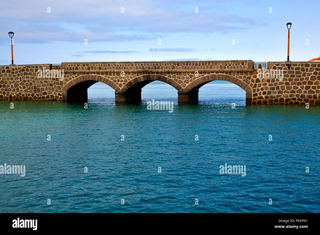 atlantic ocean lanzarote bridge and street lamp in the blue sky ...