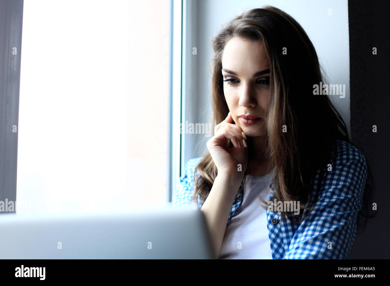 Girl working on computer in light room Stock Photo - Alamy