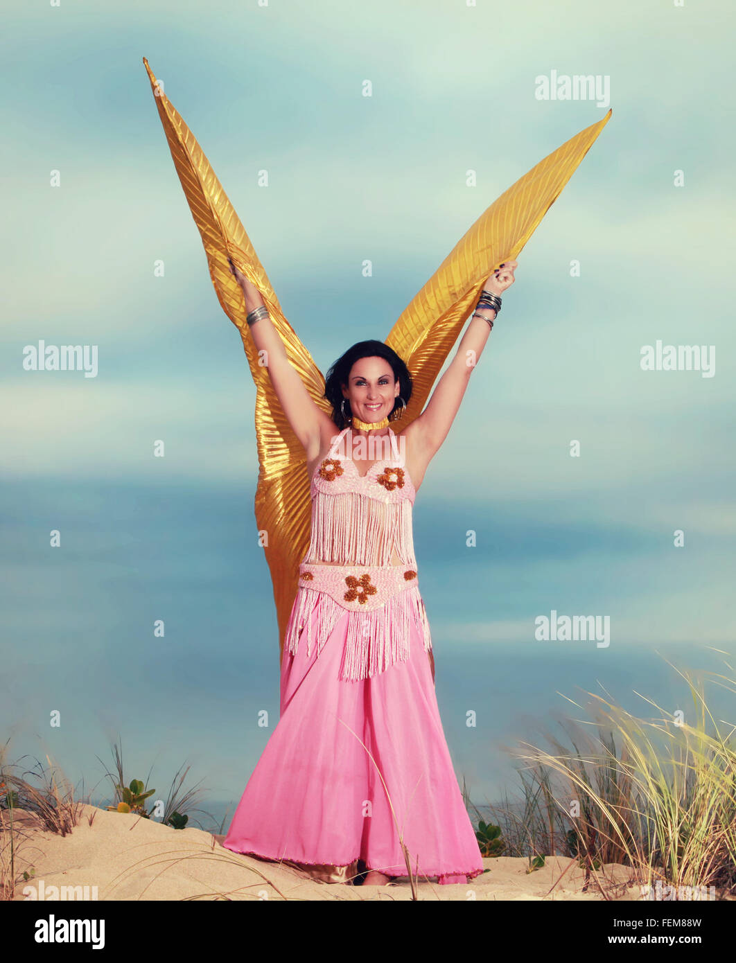 A beautiful belly dancer is performing on the beach in South Africa ...