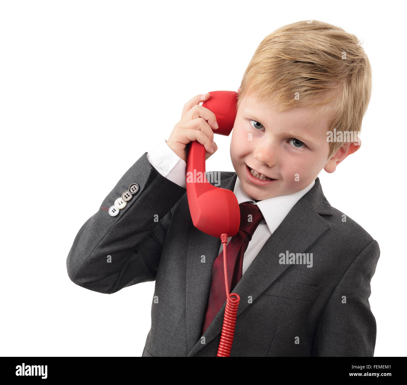 young boy in a suit talking on a red phone isolated on a white ...