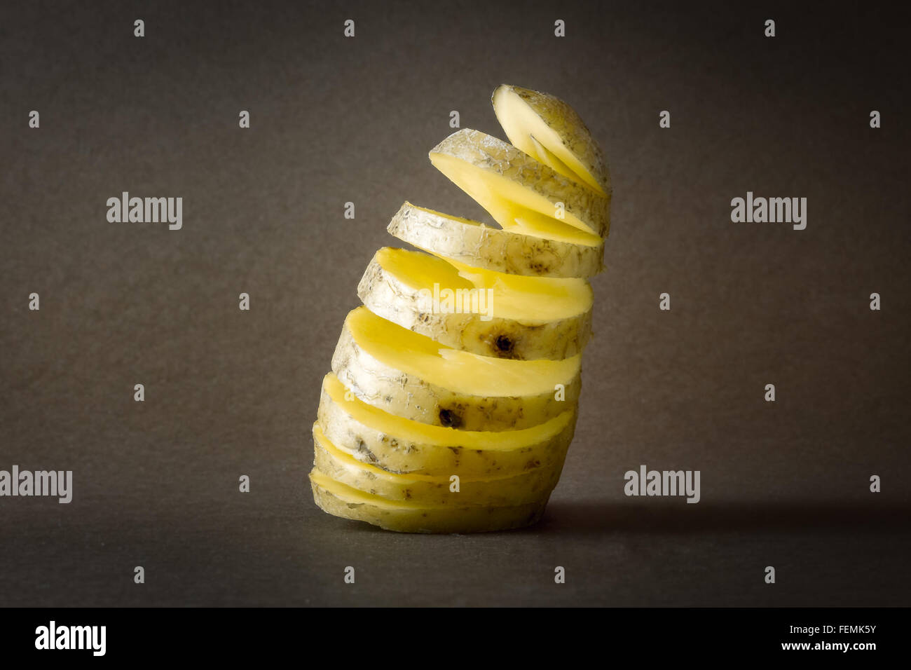 Spiral cut potato on brown background Stock Photo - Alamy