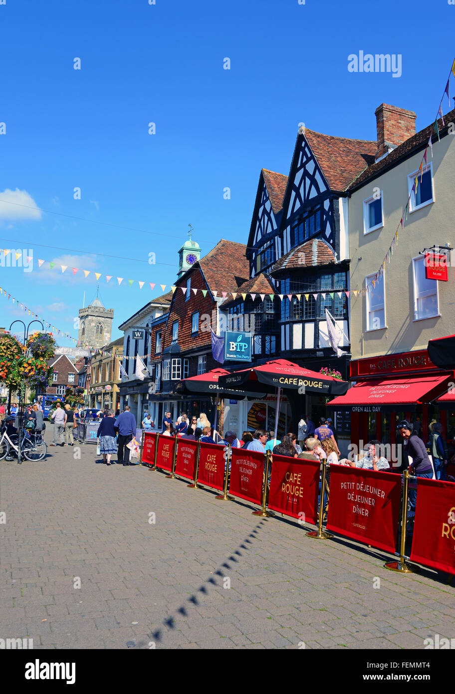 People walking and sitting at outdoor cafe tables, in the summer ...