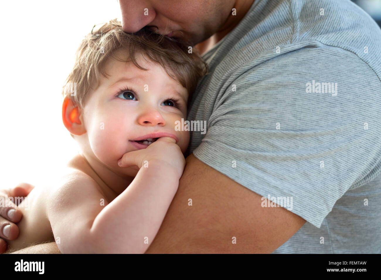 Sleepy baby boy cuddling his father Stock Photo - Alamy