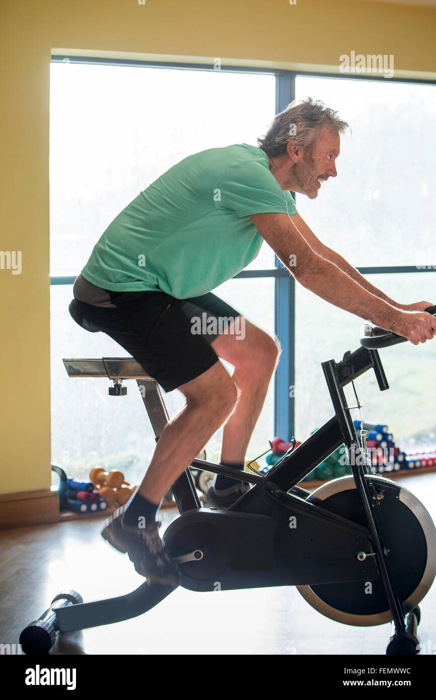 One senior man using a spinning bike at the gym Stock Photo - Alamy