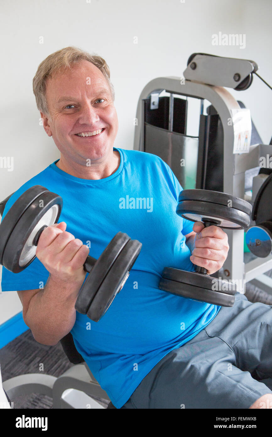 Senior man posing with weights at the gym Stock Photo - Alamy