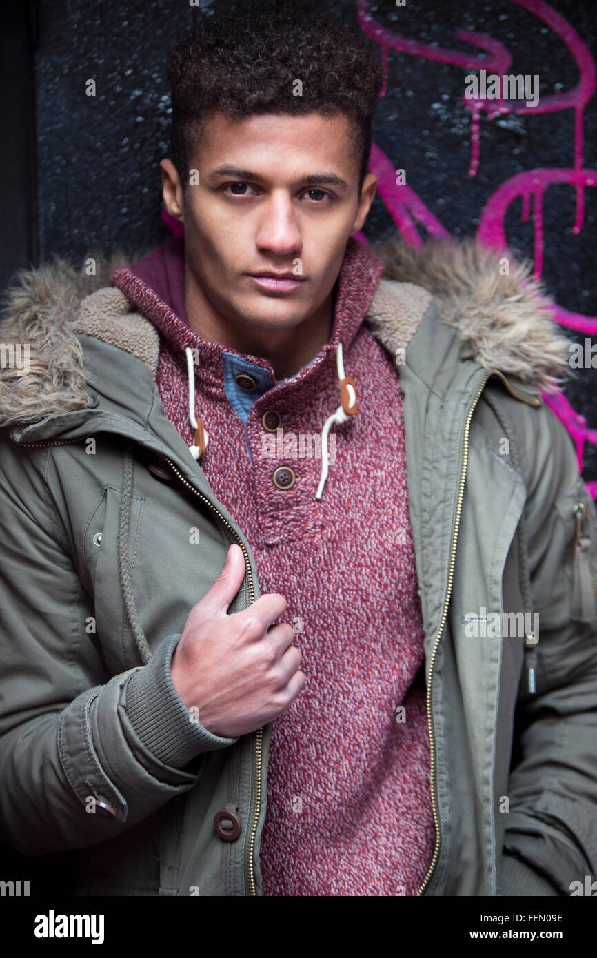 Portrait of an attractive, young, mixed-race man against an urban ...