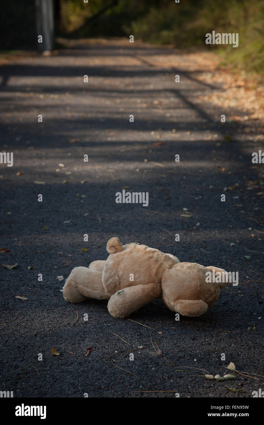 A teddy bear lays abandoned on a paved path Stock Photo - Alamy