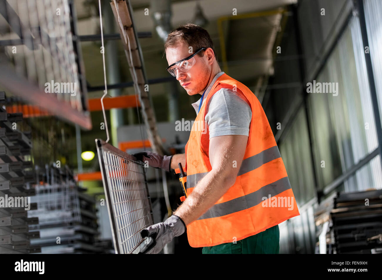 Focused worker holding steel part in factory Stock Photo - Alamy