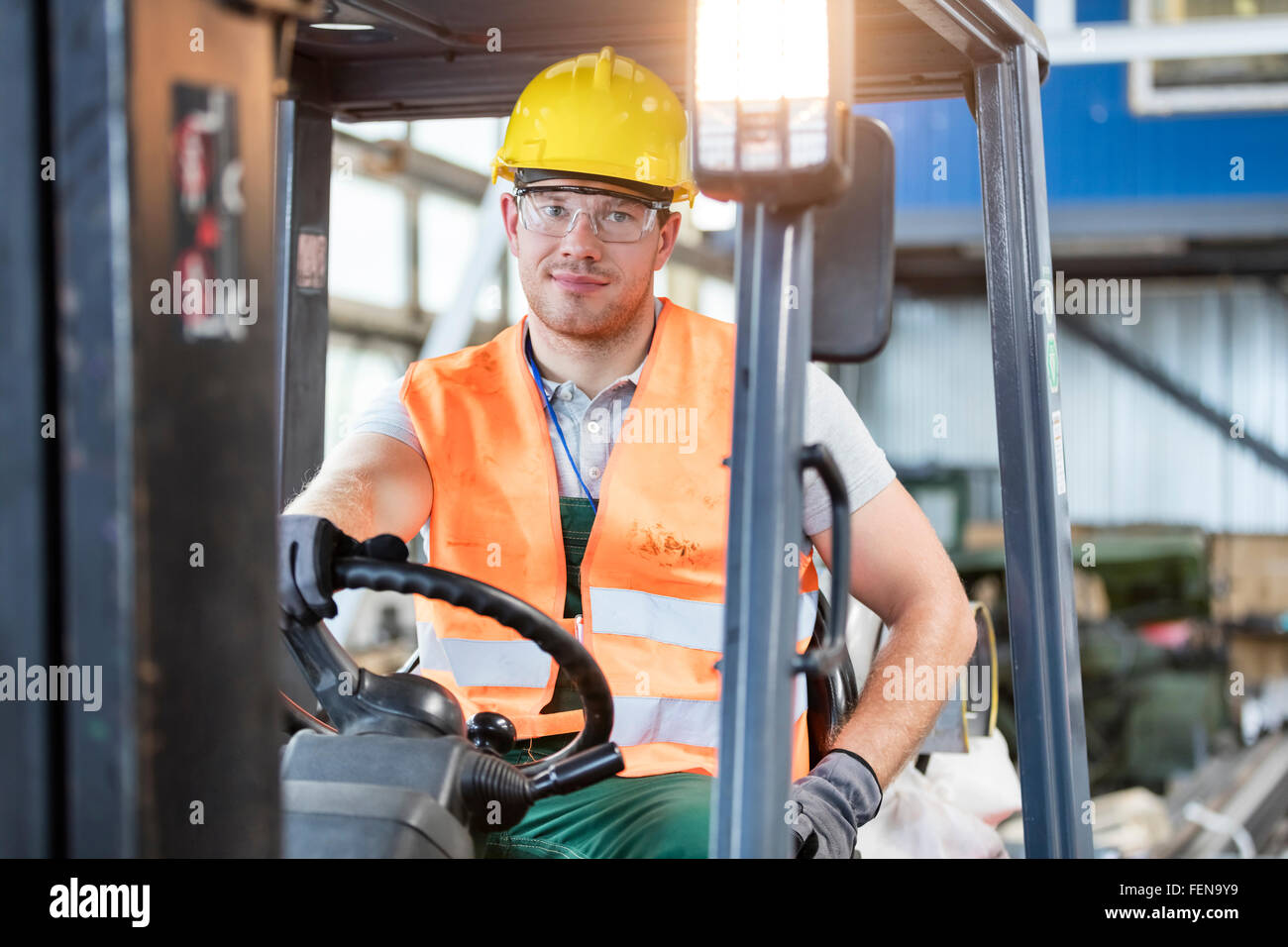 Portrait worker driving forklift in factory Stock Photo - Alamy