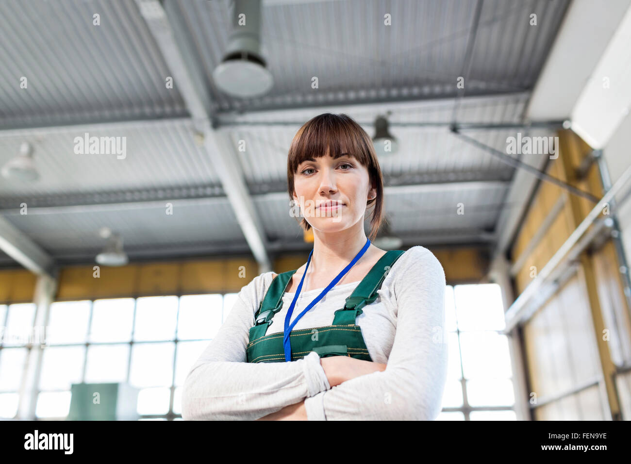 Portrait serious female worker with arms crossed in factory Stock Photo ...