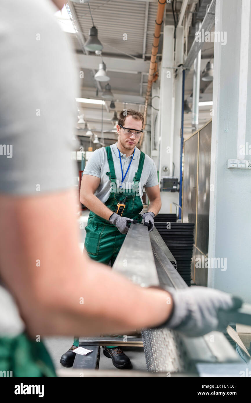 Workers lifting metal parts in factory Stock Photo - Alamy