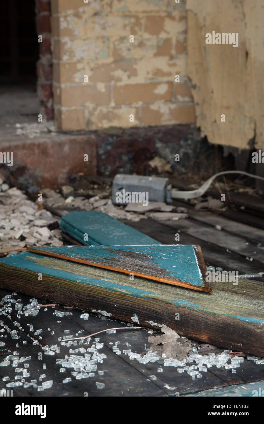 Debris sits inside the entrance of an old building. Glass and pieces of ...