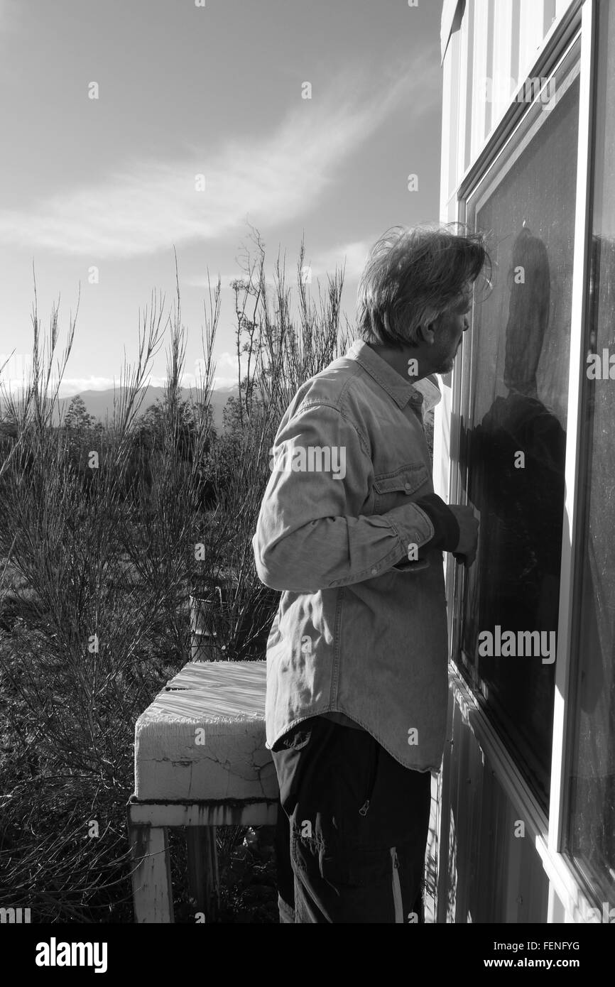 Mid Adult Man Looking Through Window While Standing Outside House By ...