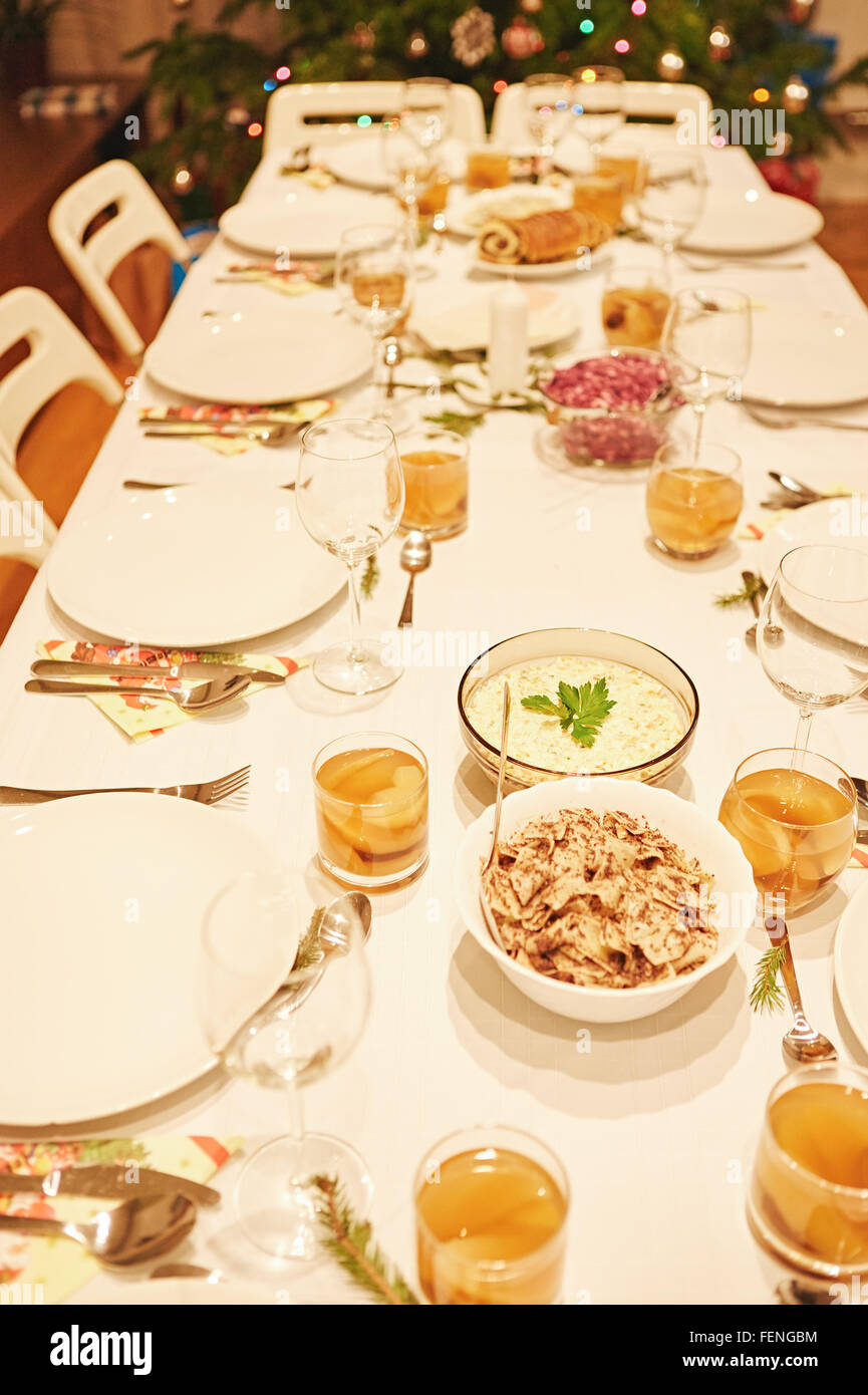 Table with festive food and Christmas tree Stock Photo - Alamy