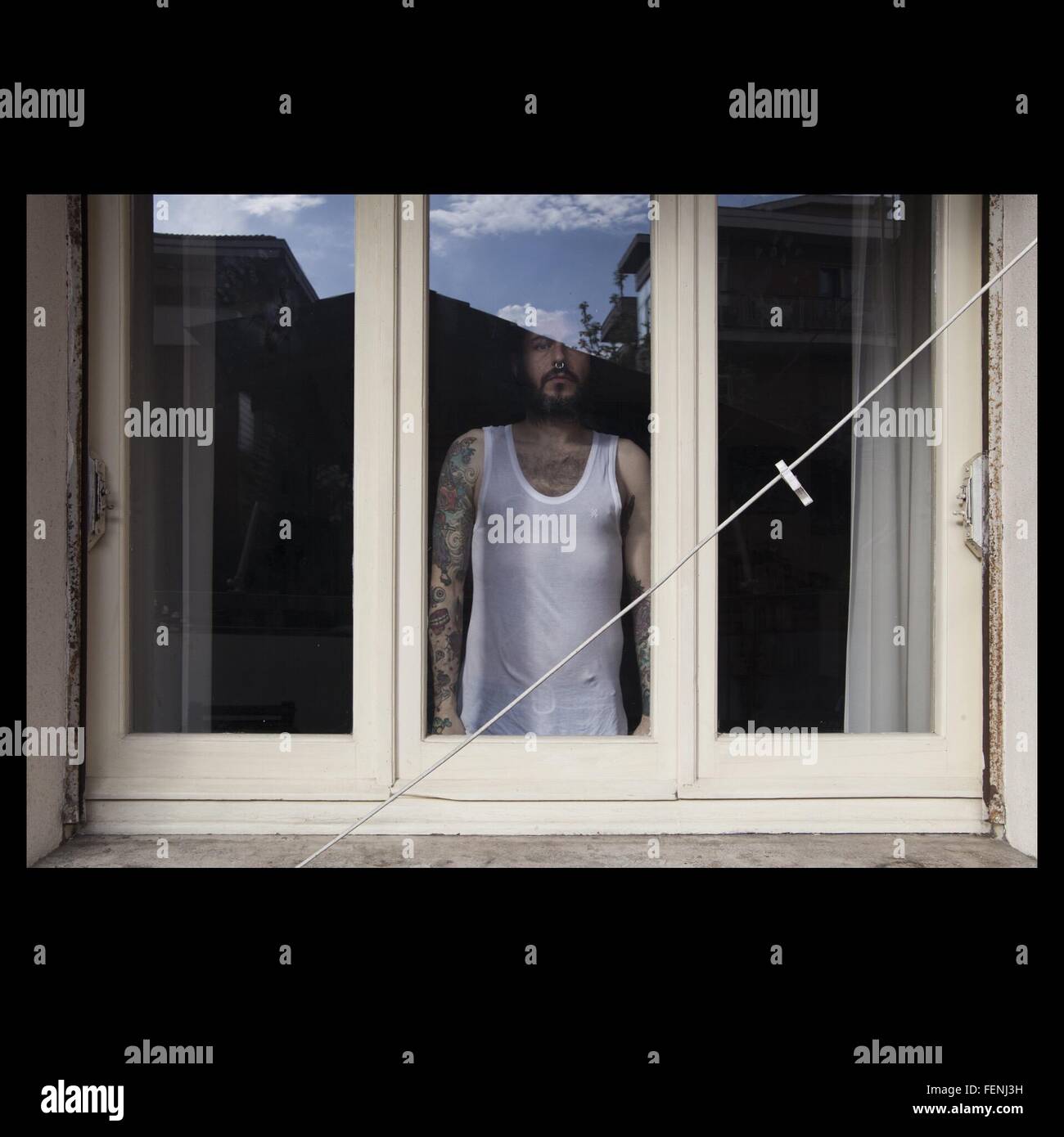 Front View Of Young Man Standing By Window Stock Photo - Alamy