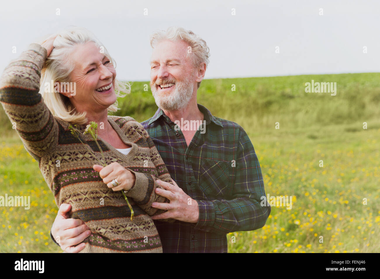 Smiling senior couple hugging in field Stock Photo - Alamy