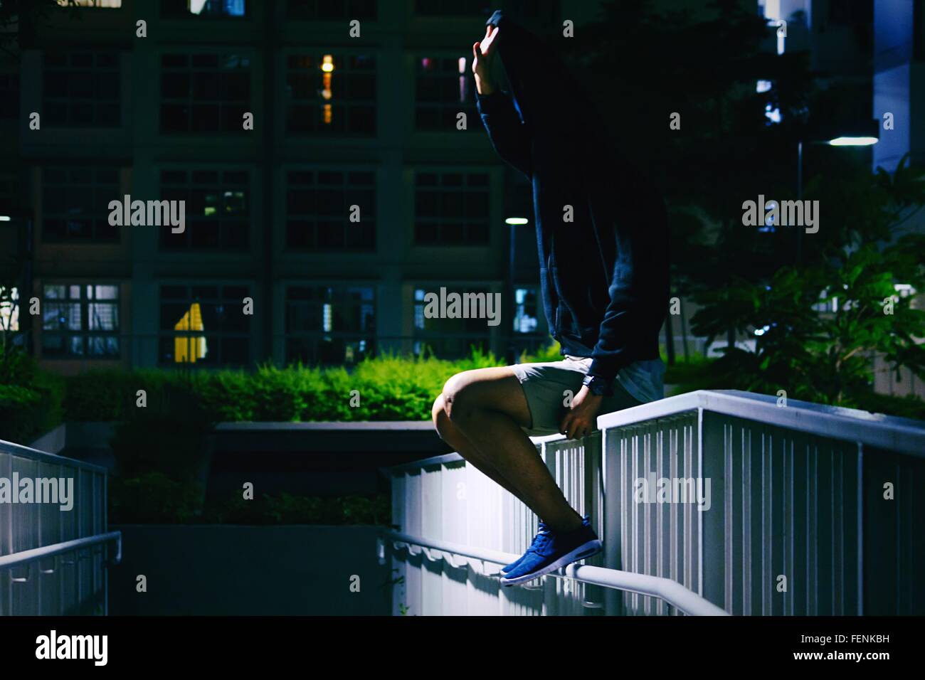 Man Sitting On Railing Stock Photo - Alamy