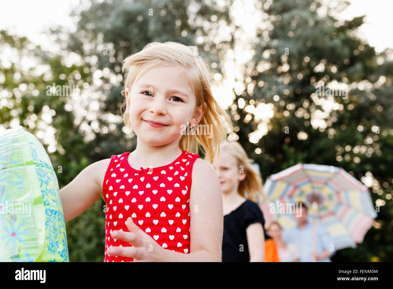 Portrait of girl playing with inflatable ring in park Stock Photo - Alamy