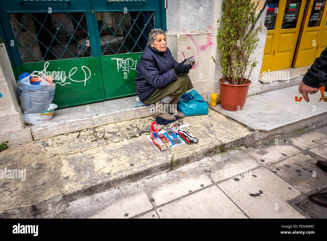 A woman selling personal possessions on the streets of Athens Stock ...