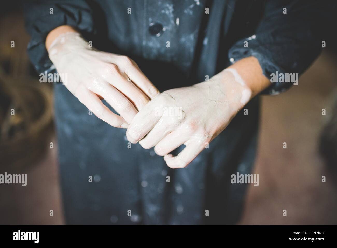 High angle cropped view of young womans clay covered hands Stock Photo ...