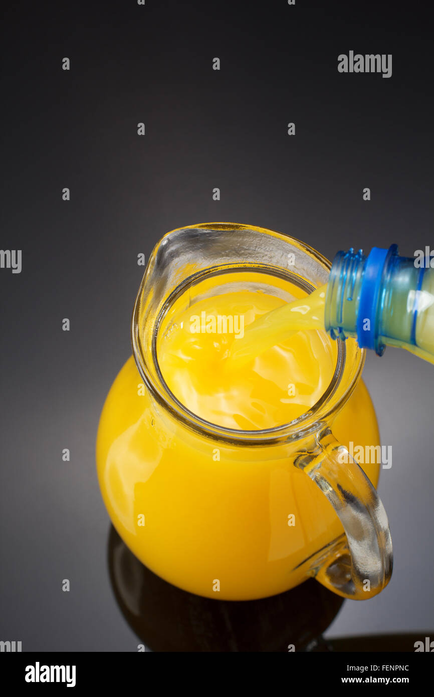 glass pitcher and orange juice on black background Stock Photo - Alamy