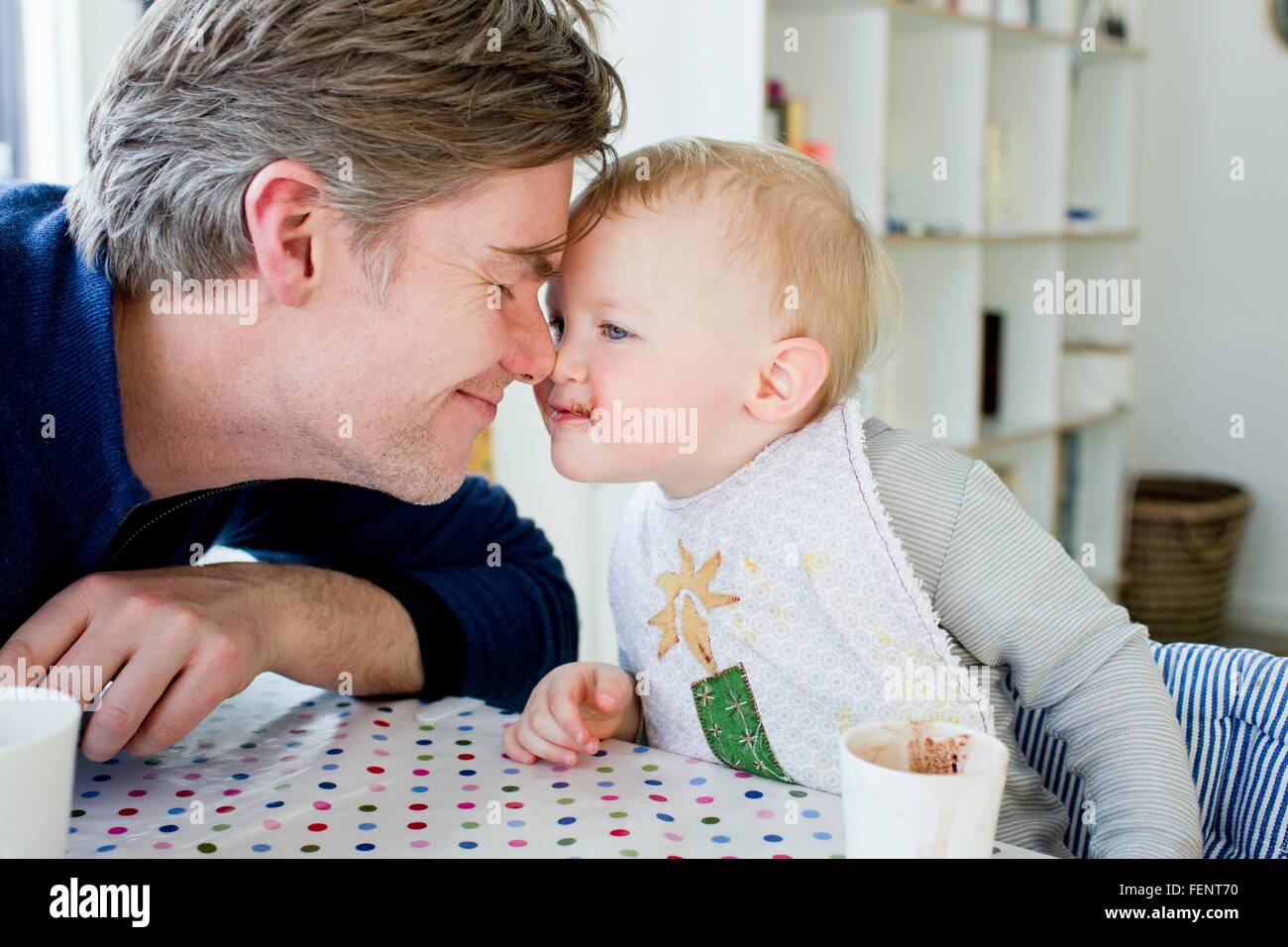 Female toddler and father face to face at kitchen table Stock Photo - Alamy