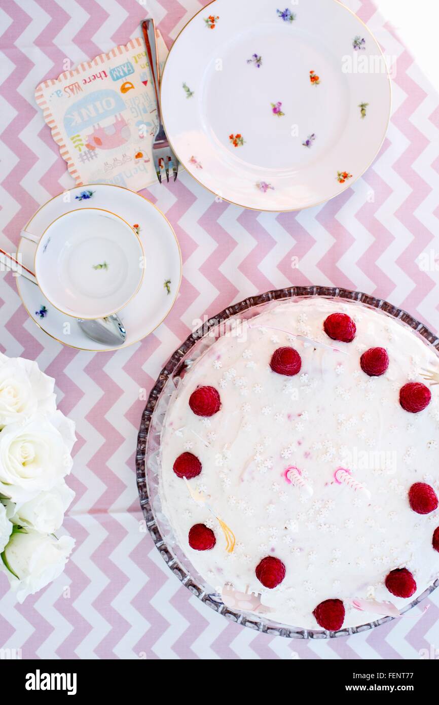 Overhead view of birthday tea party table with birthday cake and card ...