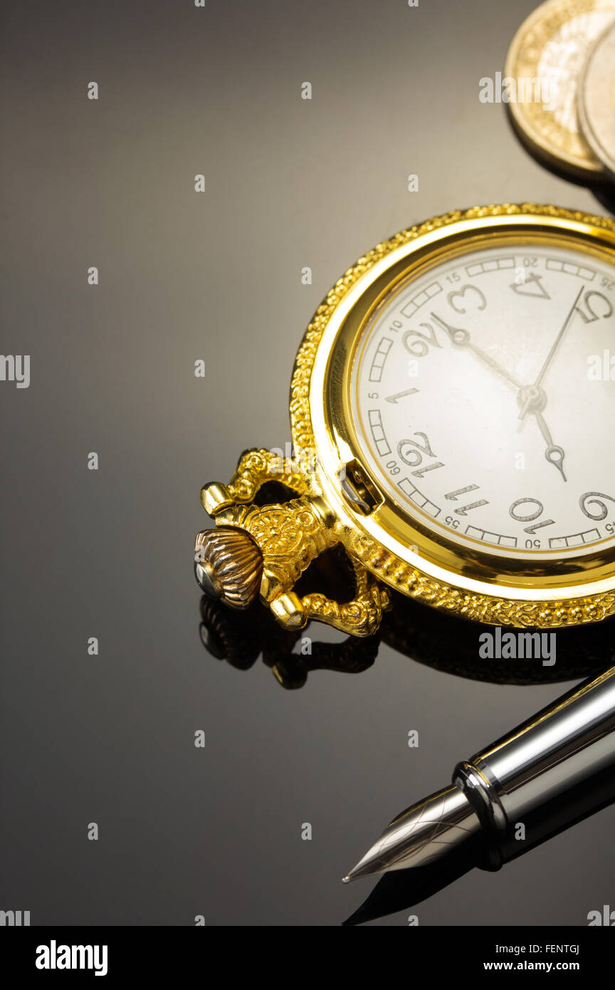 ink pen and pocket watch on black background Stock Photo - Alamy
