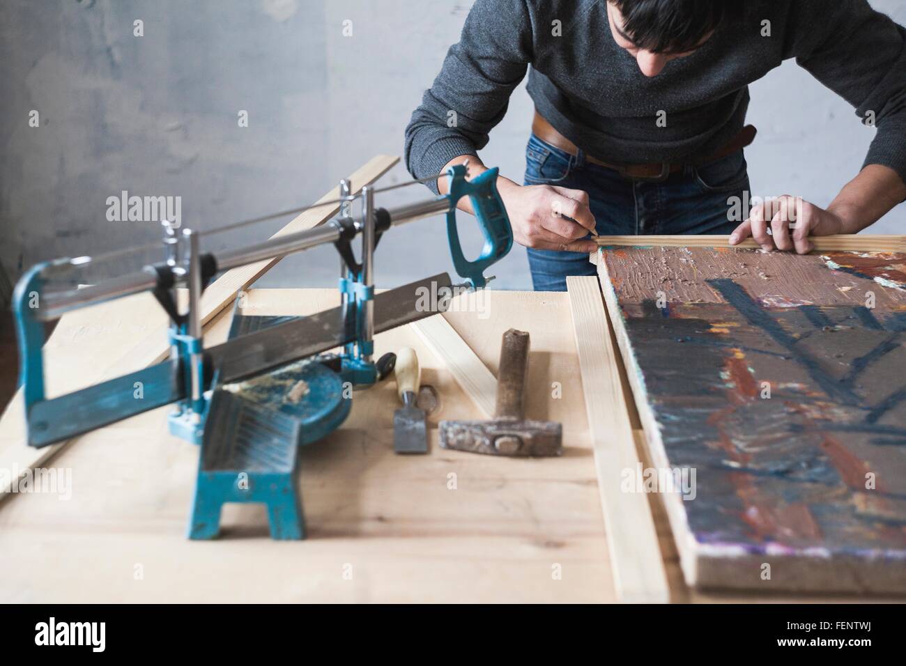 Male artist, framing artwork Stock Photo - Alamy