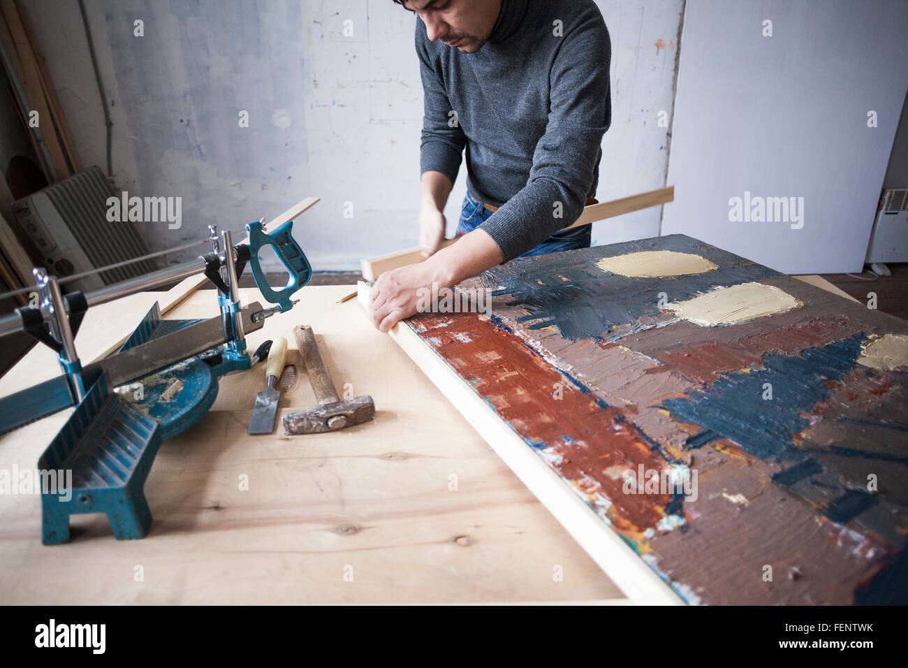 Male artist, framing artwork Stock Photo - Alamy