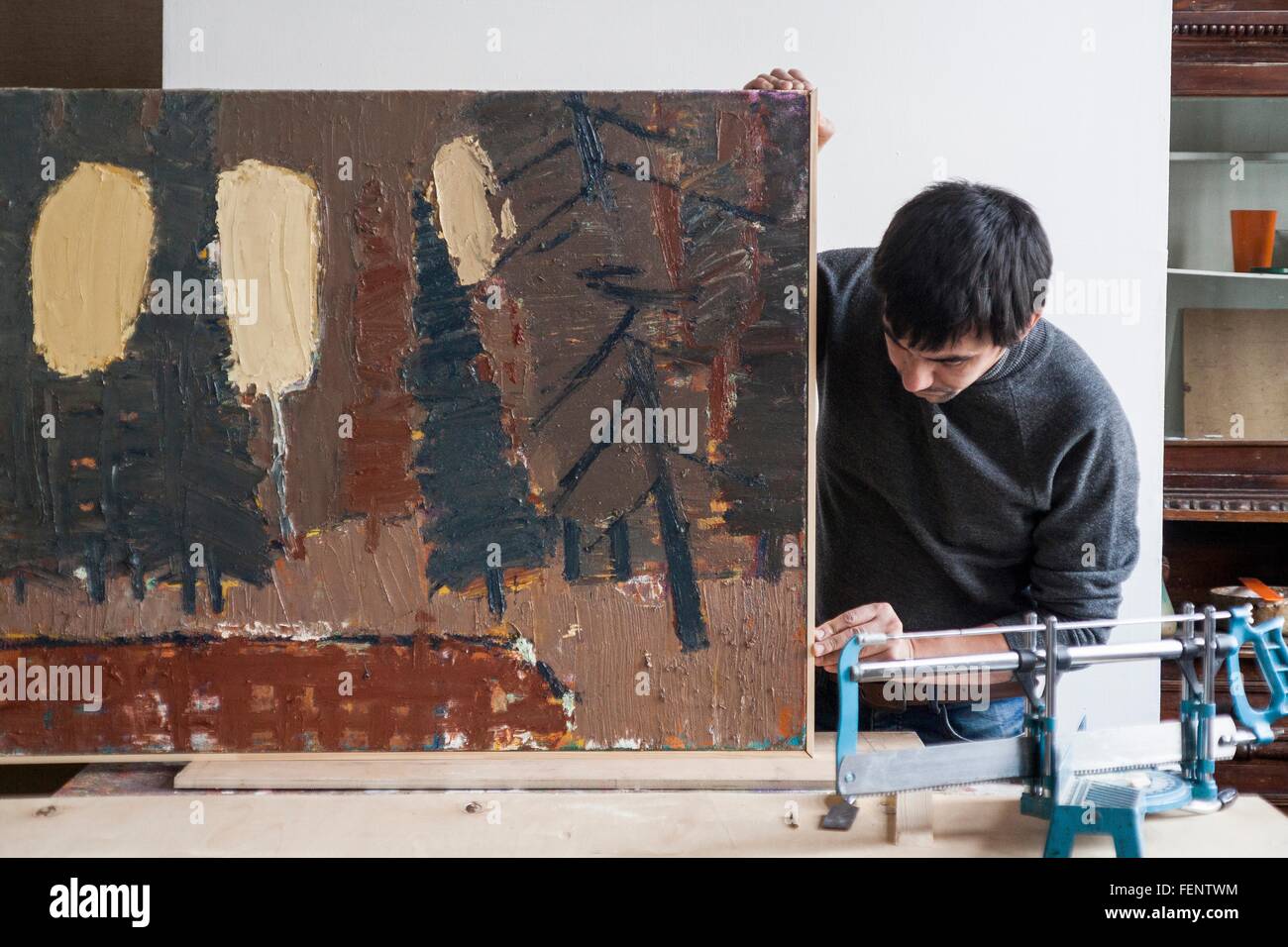 Male artist, framing artwork Stock Photo - Alamy