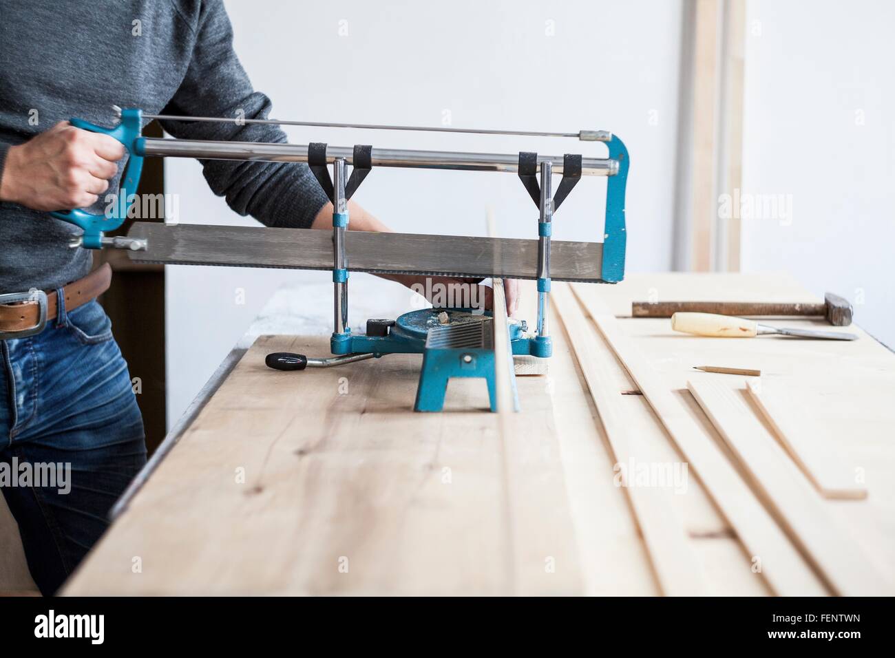 Mid adult man sawing wood Stock Photo - Alamy