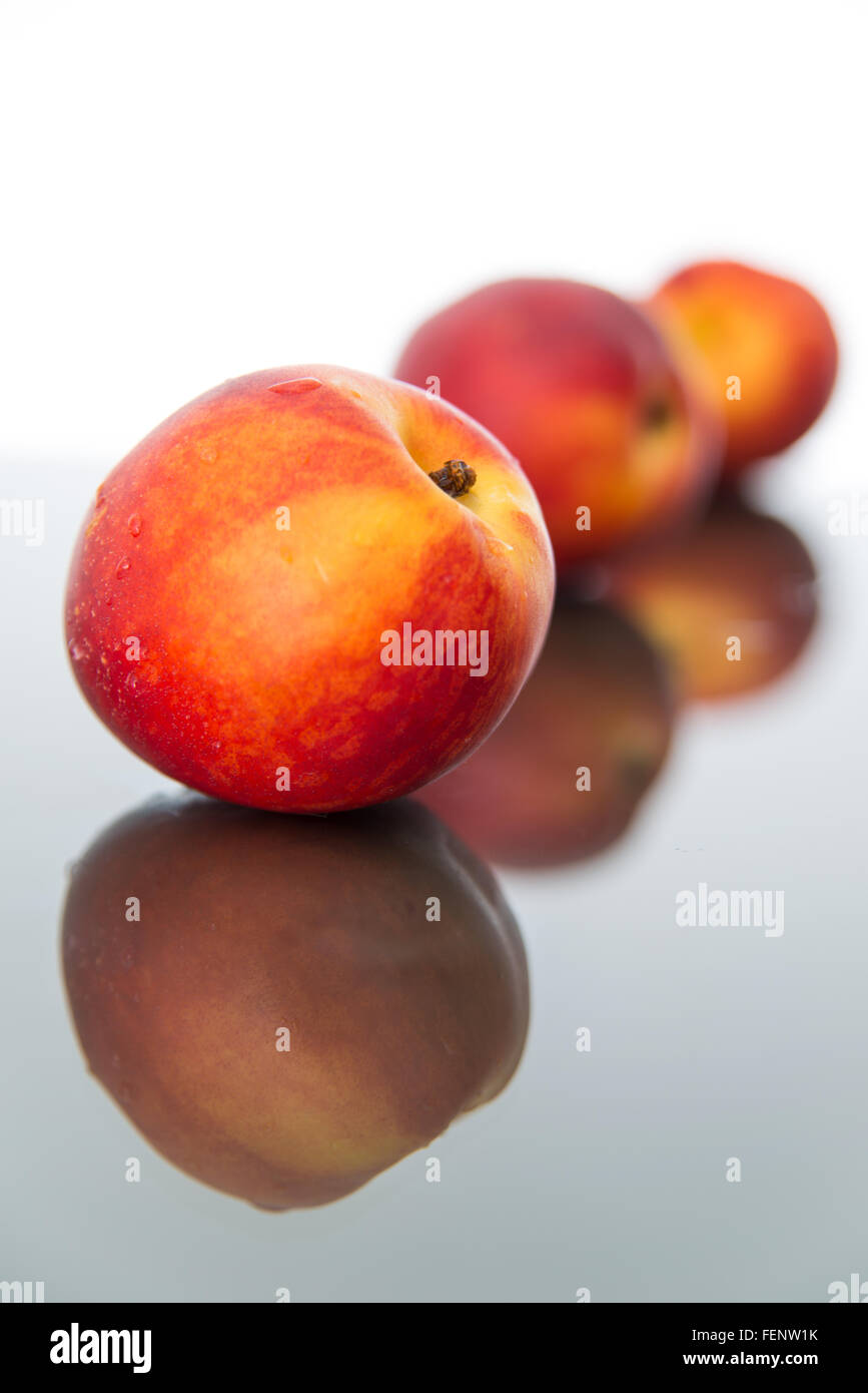yellow flesh fresh peach on glass, vertical frame, front view Stock ...