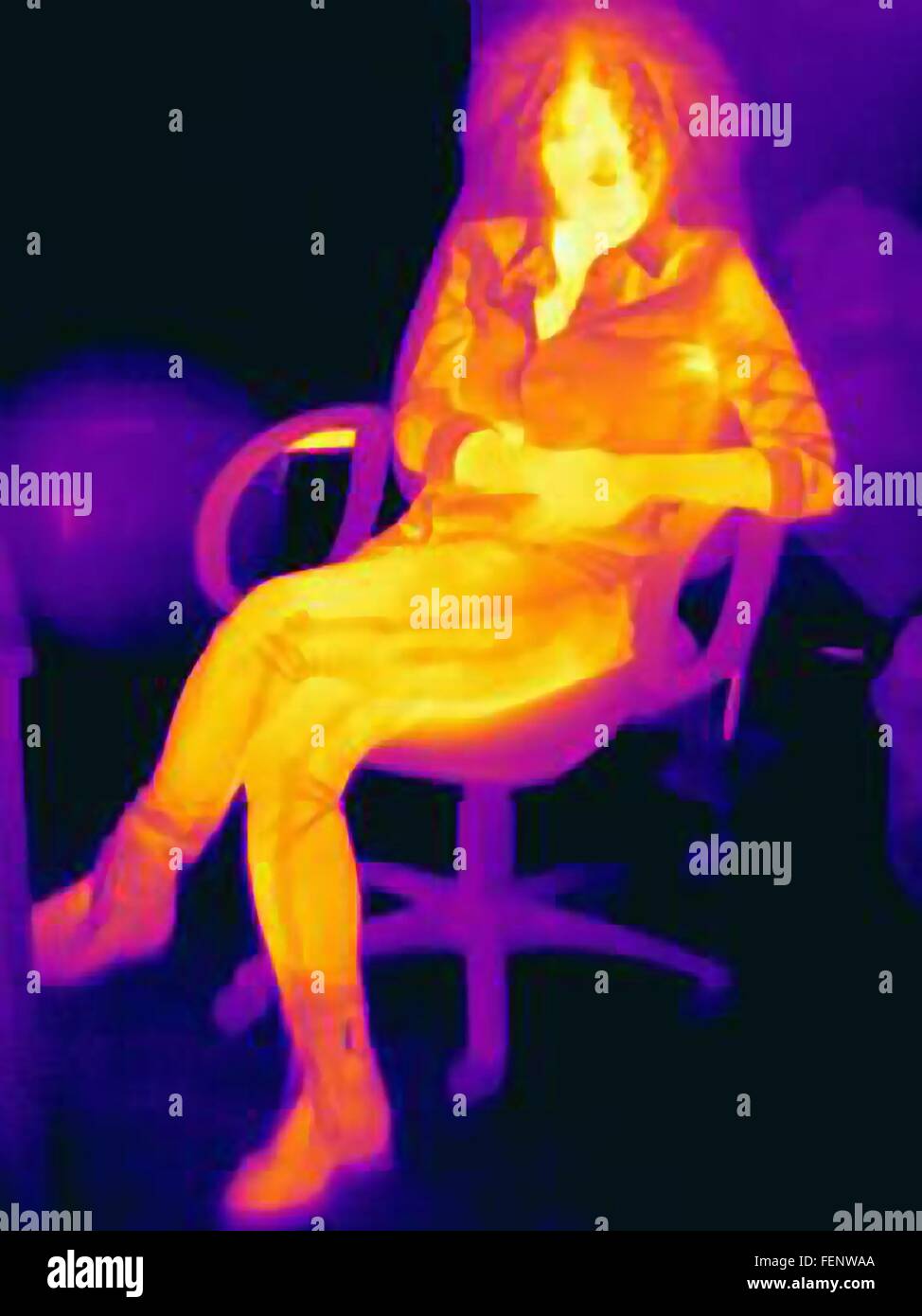 Woman with curly hair on chair, thermal image Stock Photo - Alamy