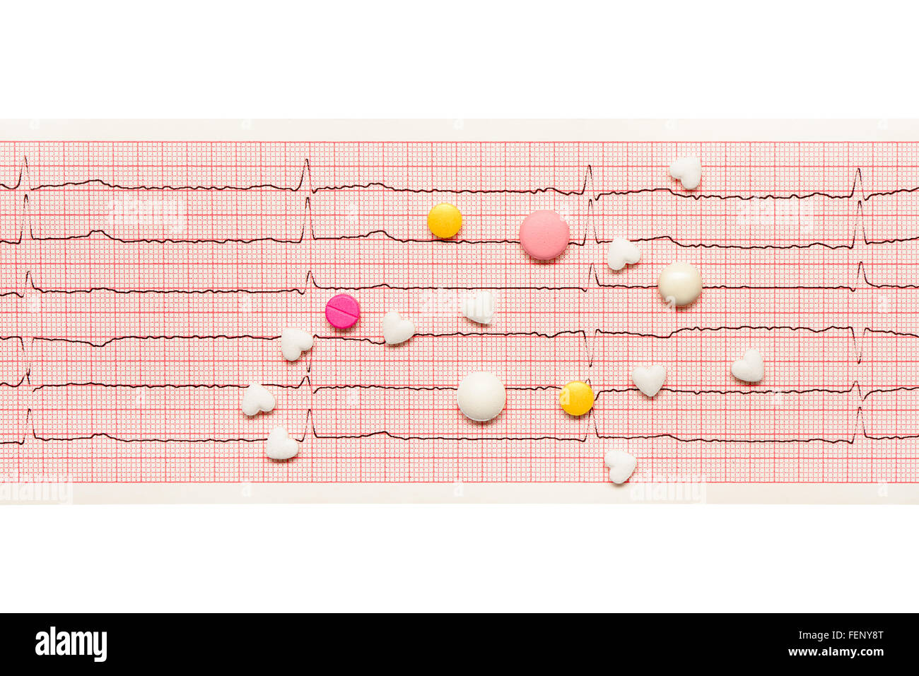 White heart shape tablets and white, yellow and pink tablets on paper ...