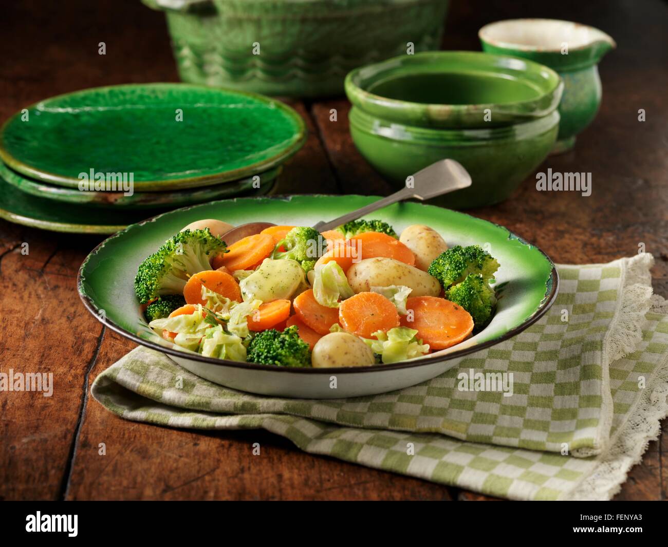 Sliced carrots, broccoli, cabbage and potatoes in ornate green serving ...