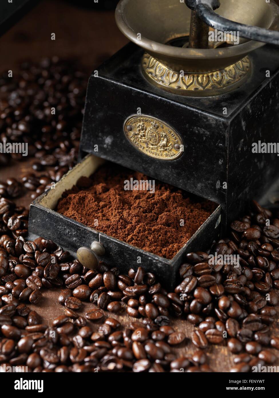Freshly ground coffee in vintage coffee grinder and raw coffee beans ...