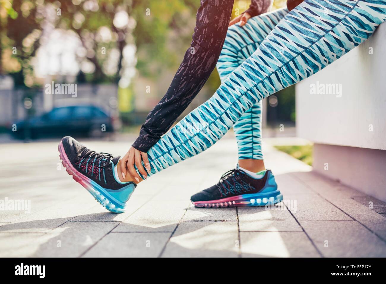 Cropped shot of female runner stretching legs on sidewalk Stock Photo ...
