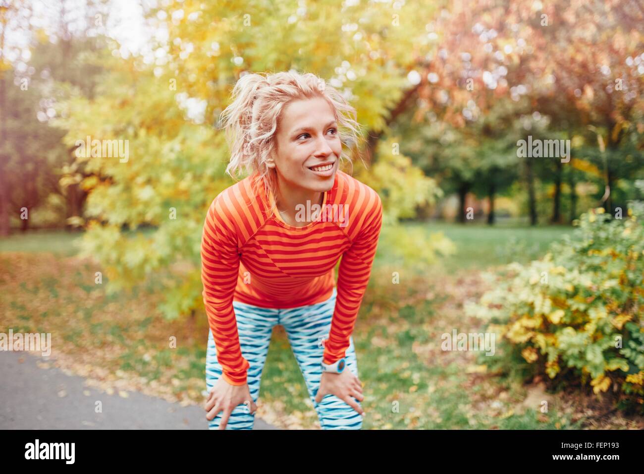 Young female runner taking a break on park path Stock Photo - Alamy