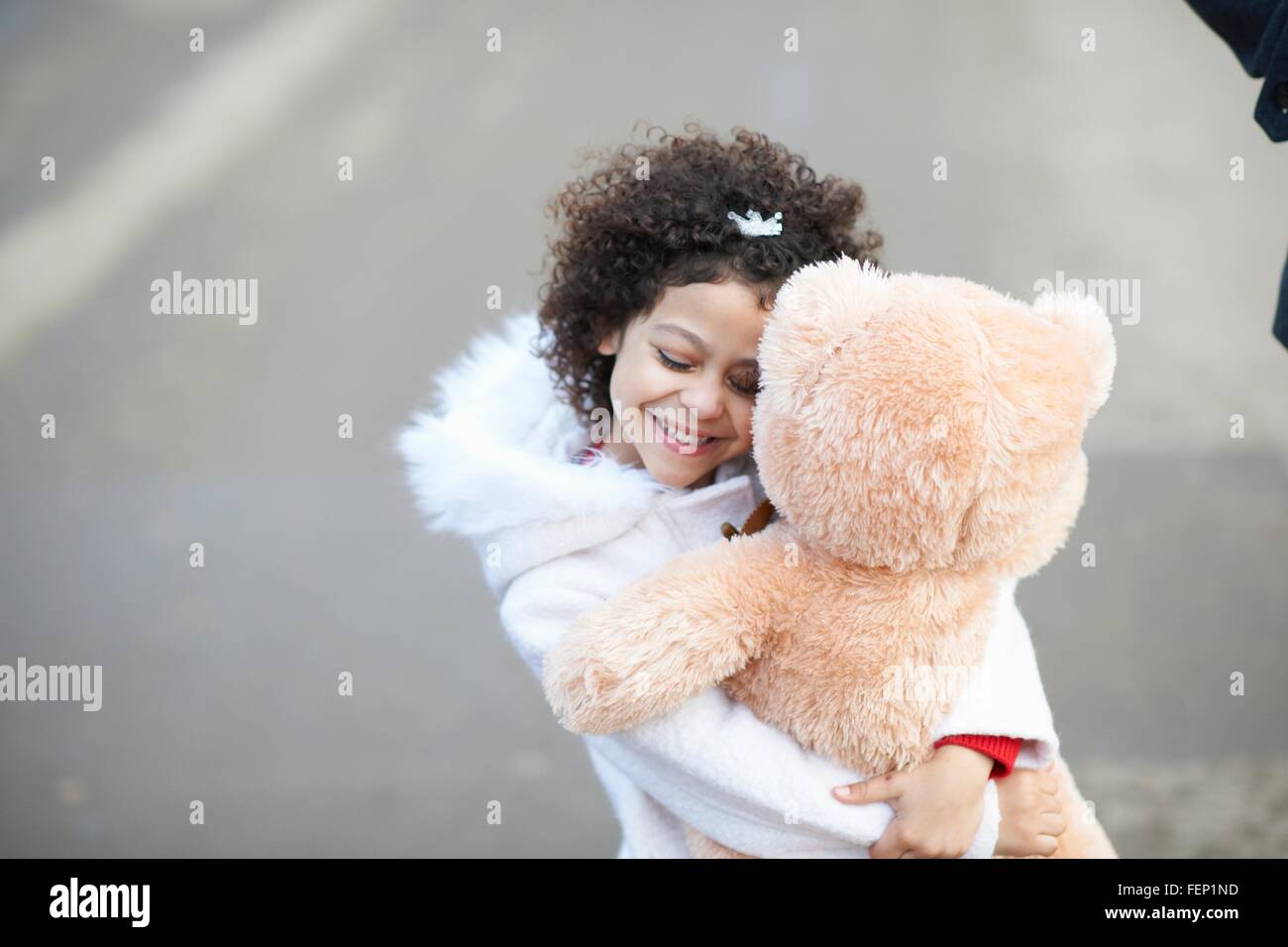 High angle view of girl, eyes closed hugging soft toy Stock Photo - Alamy