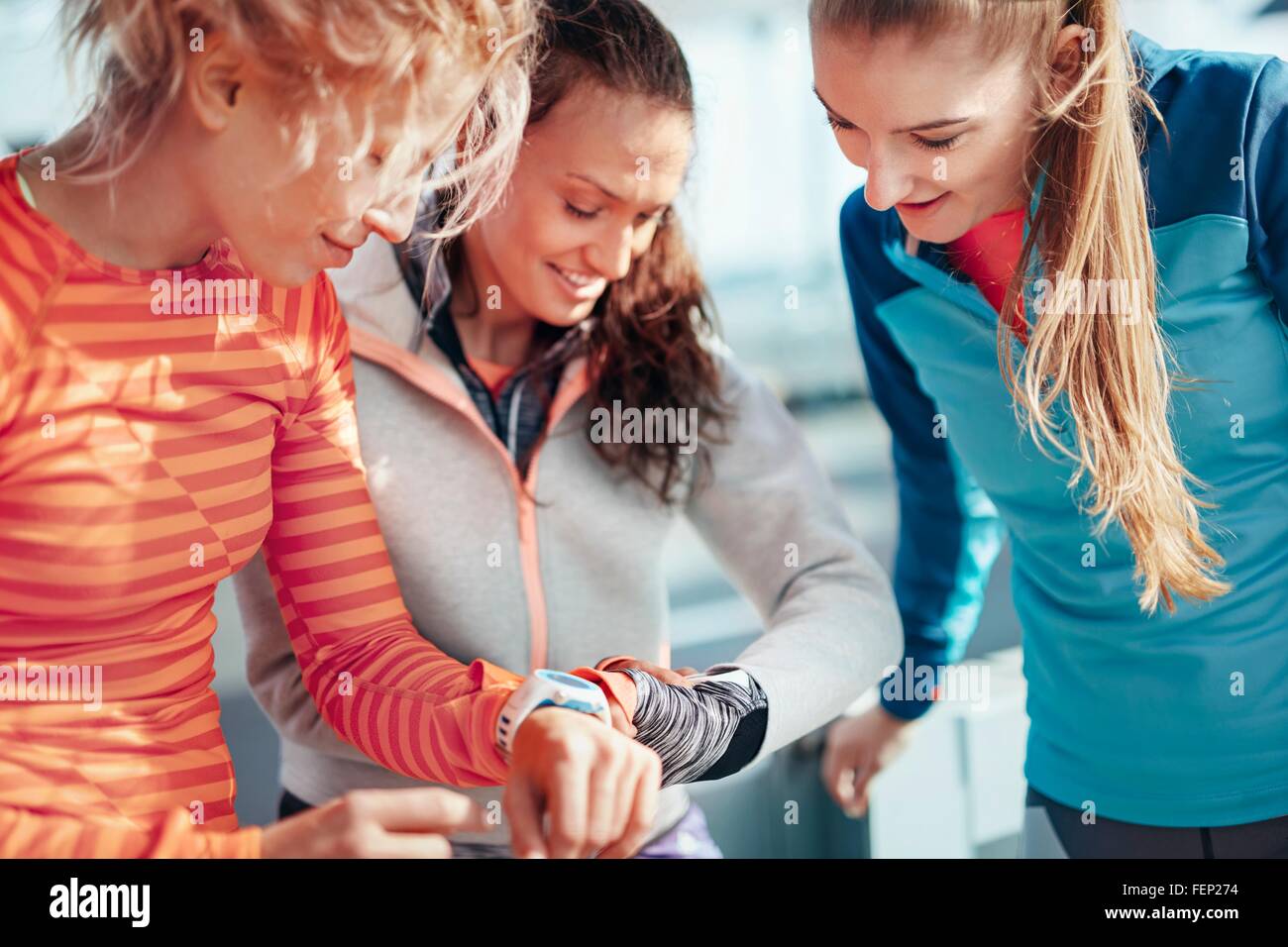 Three female runners checking time on smartwatches Stock Photo - Alamy