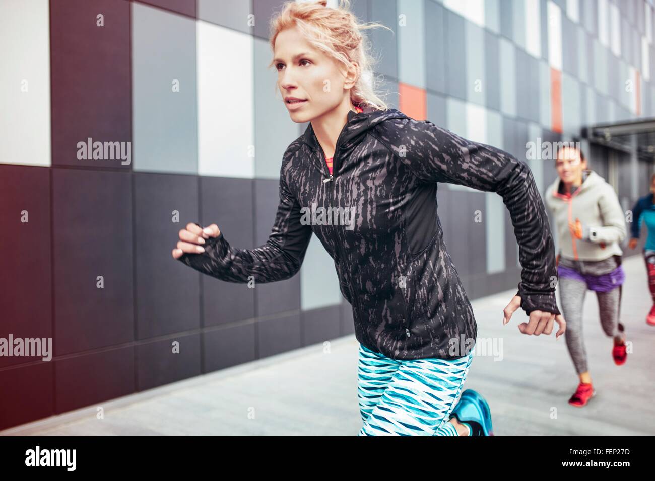 Three female runners racing up from city underpass Stock Photo - Alamy
