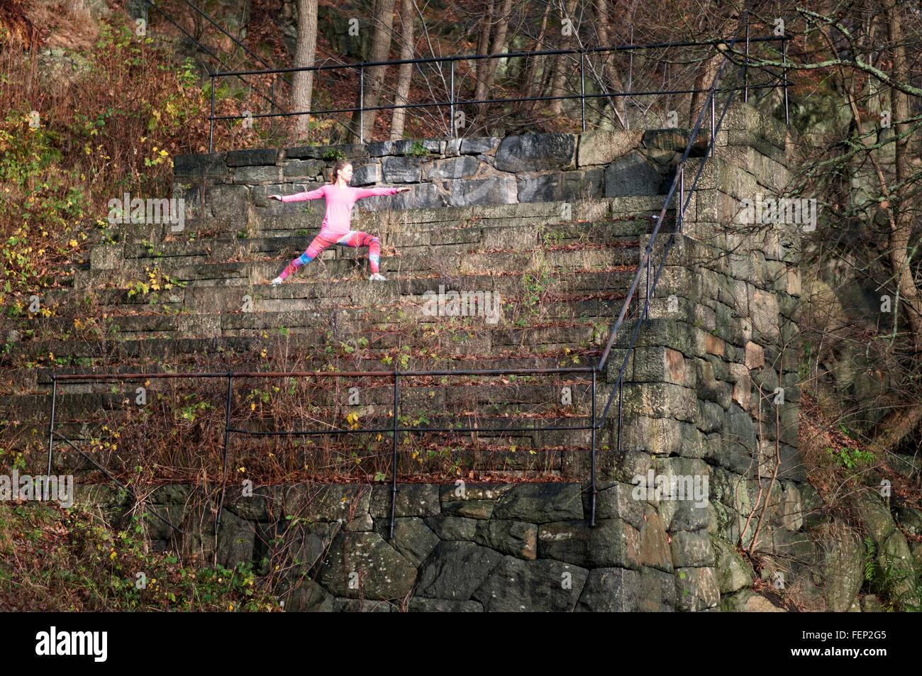 Young woman doing stretching exercises on overgrown stone steps Stock ...