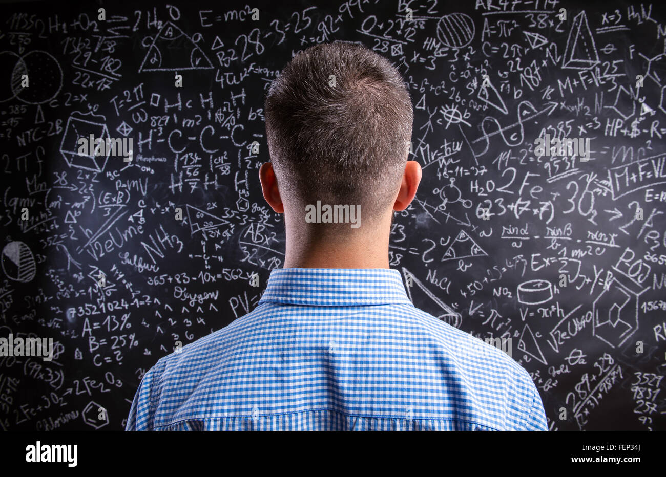 Back view of teacher against big blackboard with mathematical sy Stock ...