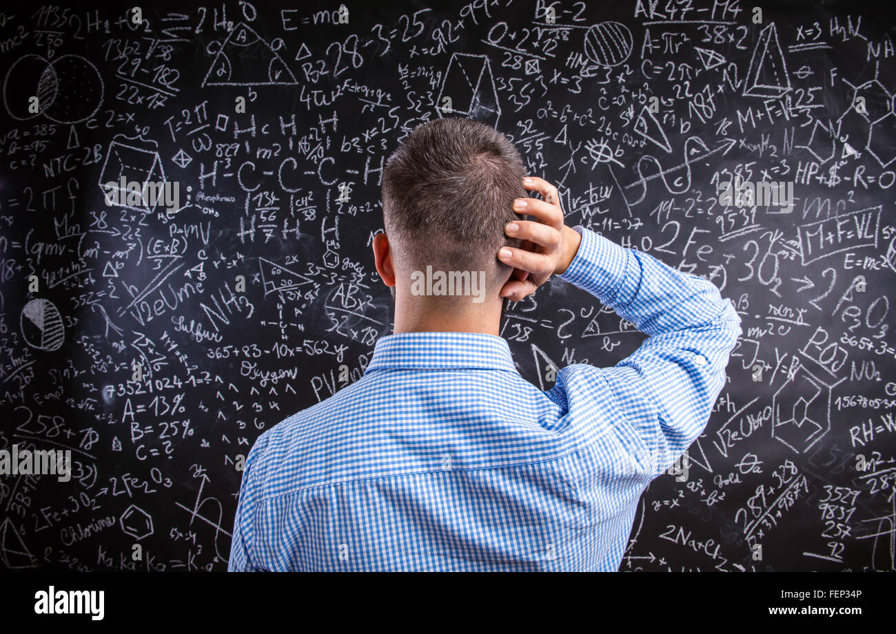 Back view of teacher against big blackboard with mathematical sy Stock ...