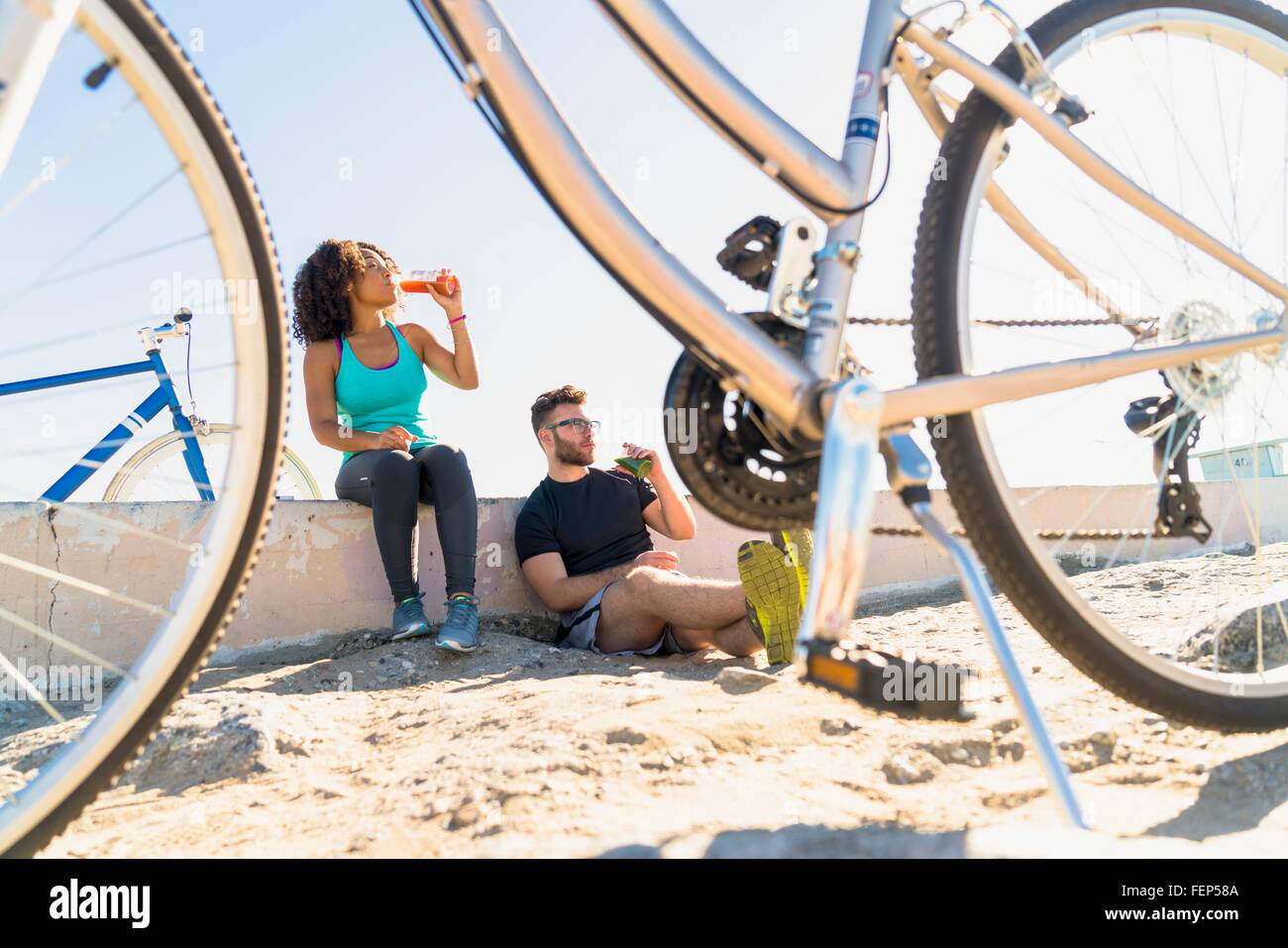 Couple relaxing after bike ride, bicycles beside them Stock Photo - Alamy