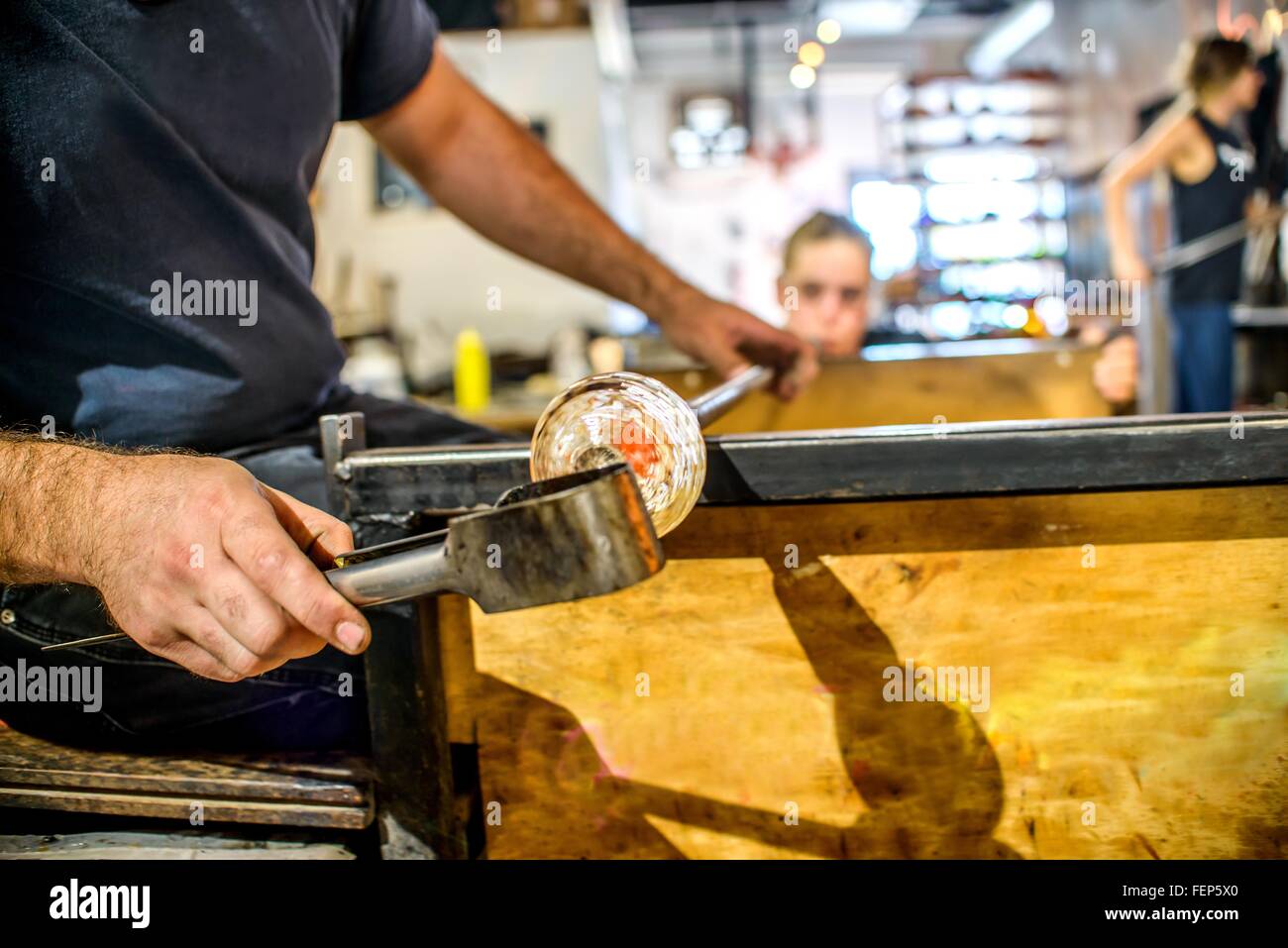 Young man blowing glass, mid section, close-up Stock Photo - Alamy